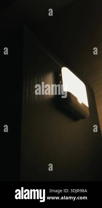 A modern motion-activated LED night light provides a warm glow in a ...