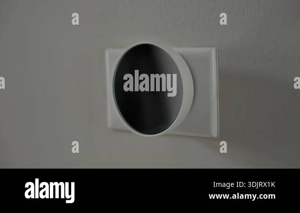 Close-up of man hand adjusting a smart home thermostat showing a ...