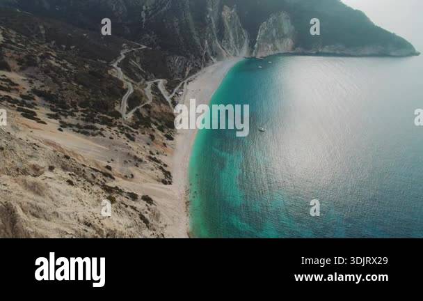 Aerial view of long beach Myrtos and turquoise sea by mountain slopes ...