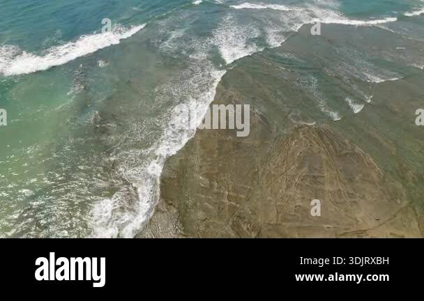 Ocean tide covers rocky coastal shelf with turquoise ocean waters in ...