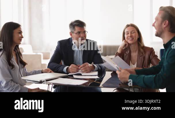 Team reviewing reports and financial updates during meeting, discussing ...