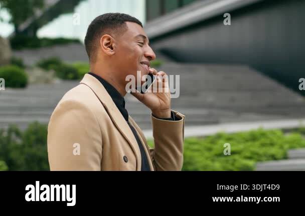 Happy African American business man talking mobile phone in city ...