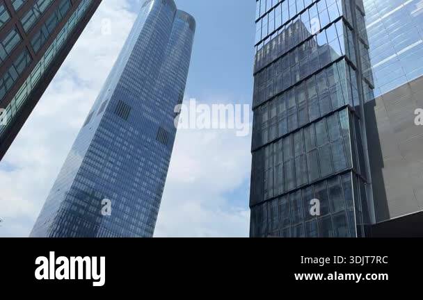 Tall modern glass skyscrapers rise into the blue city sky. Reflective ...