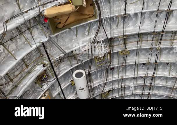Detailed view of an aircraft cargo bay ceiling shows silver insulation ...
