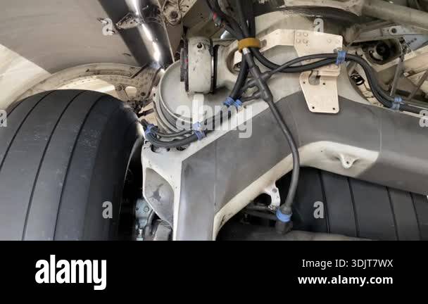 Detailed view of an aircraft landing gear wheel with hydraulic lines ...