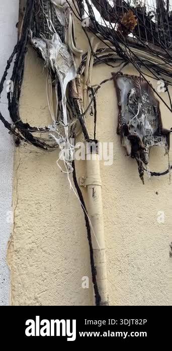 Damaged electrical infrastructure on a wall showing the aftermath of a ...