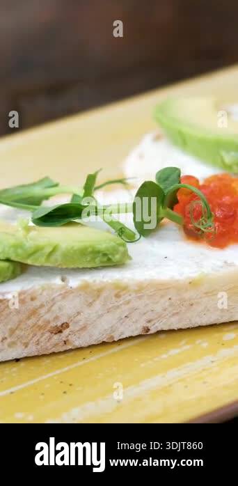 Healthy avocado toast with poached egg and fresh greens on rustic plate ...