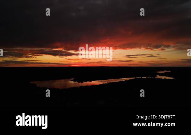Dramatic aerial sunset over winding river and dark storm clouds. Aerial ...