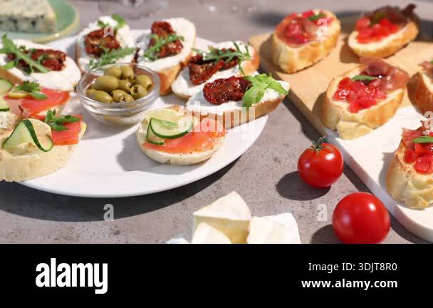 Woman putting tasty bruschetta with salmon, cucumber and lemon onto ...