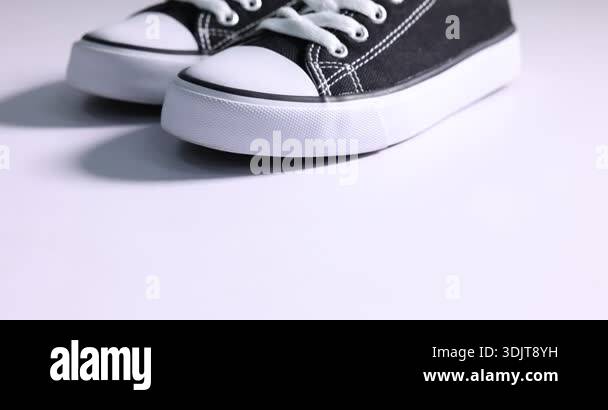 Stylish kid's sneakers on white table against grey background, closeup ...