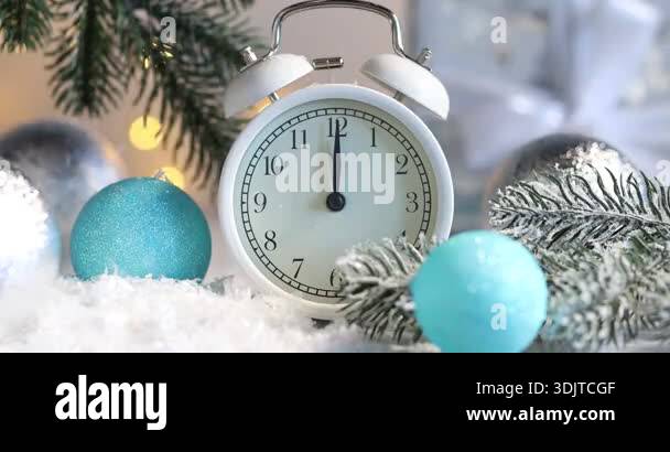 Adding artificial snow onto alarm clock, baubles and fir tree branches ...