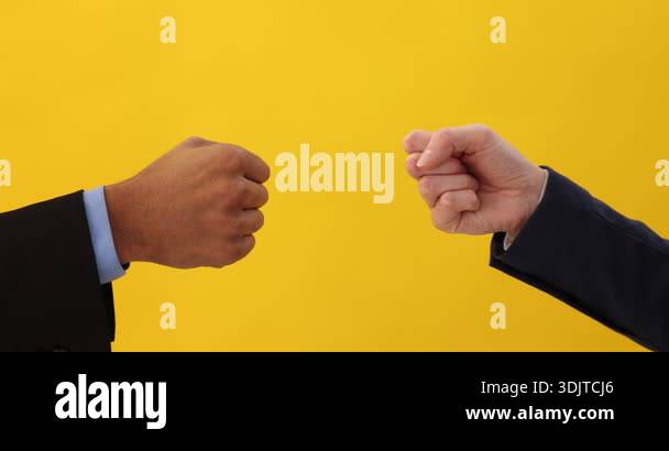 African American man bumping fists with his business partner on yellow ...