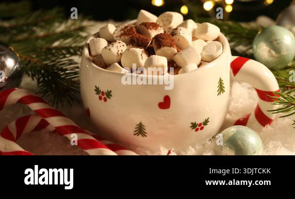 Sprinkling chocolate powder onto tasty cocoa with marshmallows, candy ...