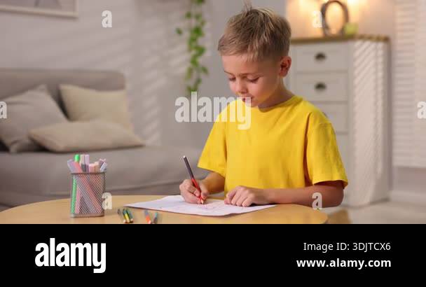Cute little boy drawing at wooden table indoors Stock Video Footage - Alamy