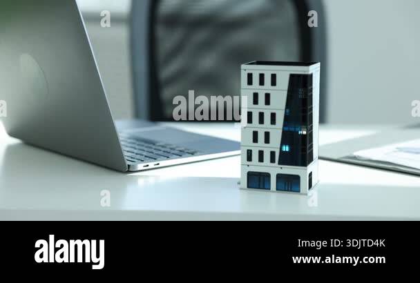 Real estate. Apartment building model, architectural drawings, laptop ...