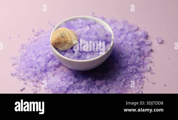 Sea salt and shell in bowl on violet background, spinning Stock Video ...