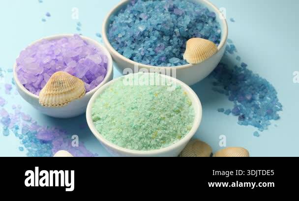 Different types of sea salt and shells on light blue background ...