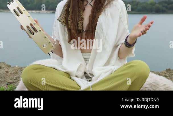 Shaman woman with face painting and tambourine performing ritual near ...