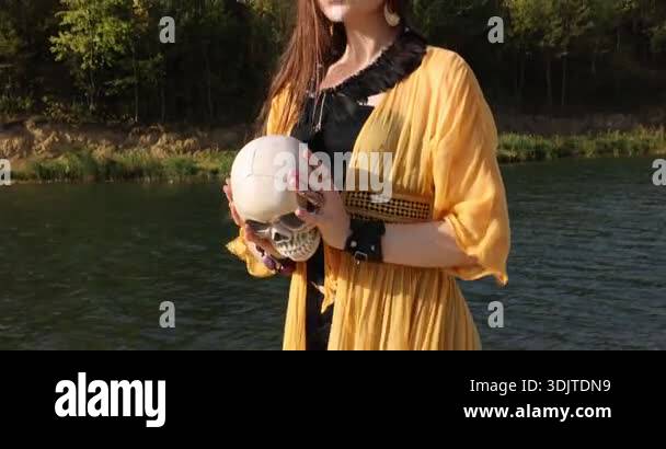 Beautiful shaman woman with face painting and skull performing ritual ...