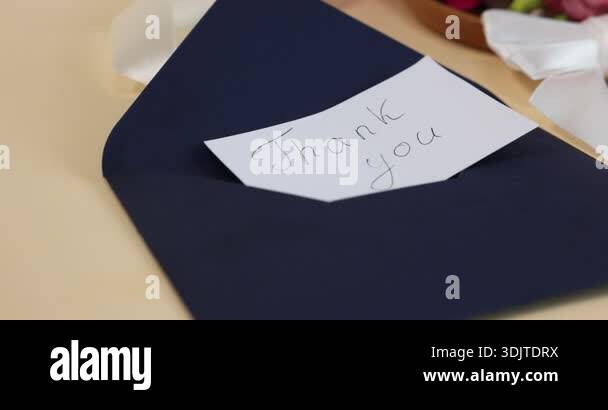 Thank you card in envelope and bouquet of flowers on beige background ...