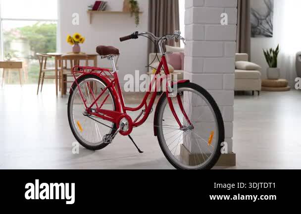 Stylish red bicycle near column at home Stock Video Footage - Alamy
