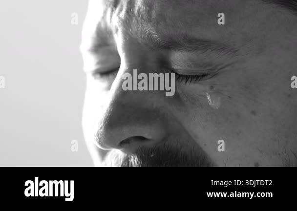 Sad man crying on light background, closeup. Black and white effect ...