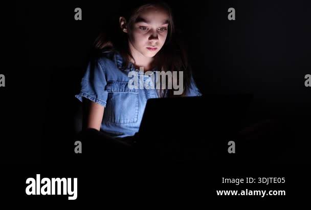 Cyber danger. Frightened girl using laptop on dark background Stock ...