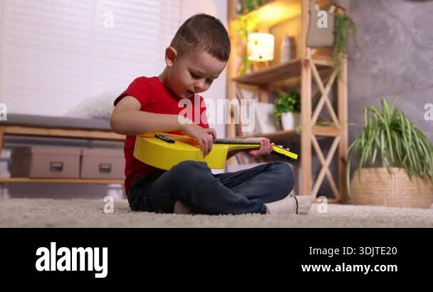 Cute little boy playing toy guitar at home Stock Video Footage - Alamy