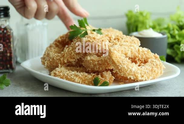 Woman dipping tasty deep fried squid ring into sauce at grey textured ...