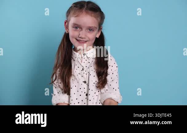 Smiling little girl posing on light blue background Stock Video Footage ...