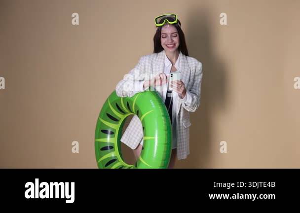 Businesswoman with diving mask and inflatable ring having video chat ...
