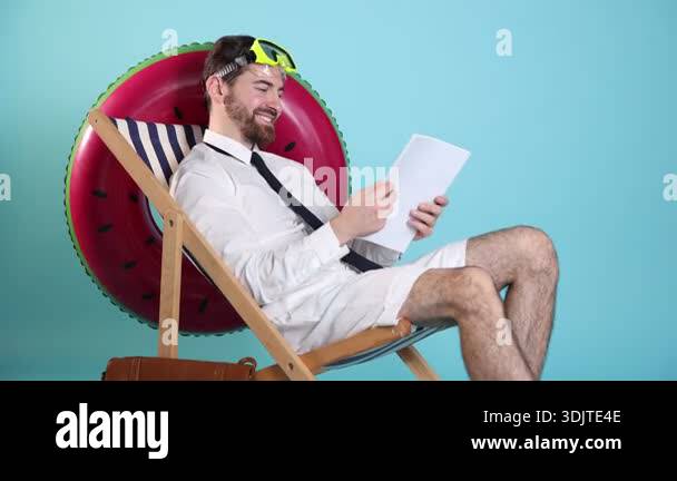Businessman with magazine and diving mask in deck chair on light blue ...