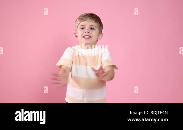 Cute little boy waving hello and clapping hands on pink background ...