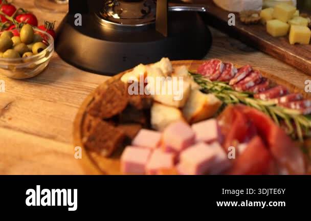 Fondue with tasty melted cheese, snacks and wine on wooden table ...