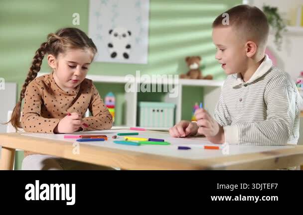 Children drawing with crayons at table indoors Stock Video Footage - Alamy