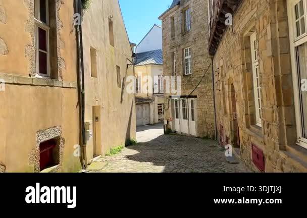 Sunny view of a narrow alley with old stone and plaster buildings ...