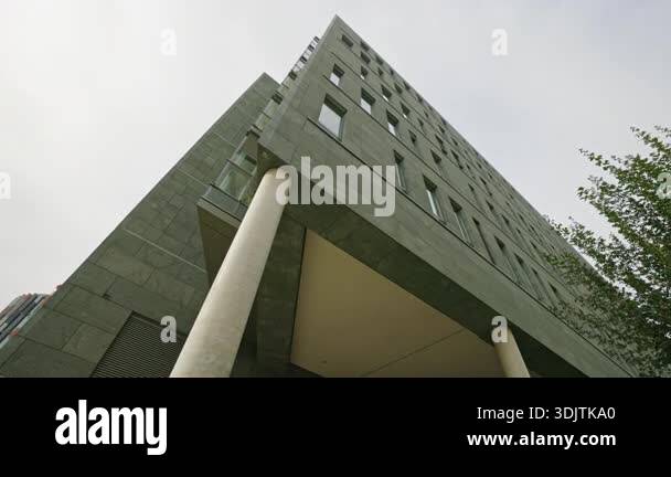 Low angle view of modern office building with stone facade, columns and ...