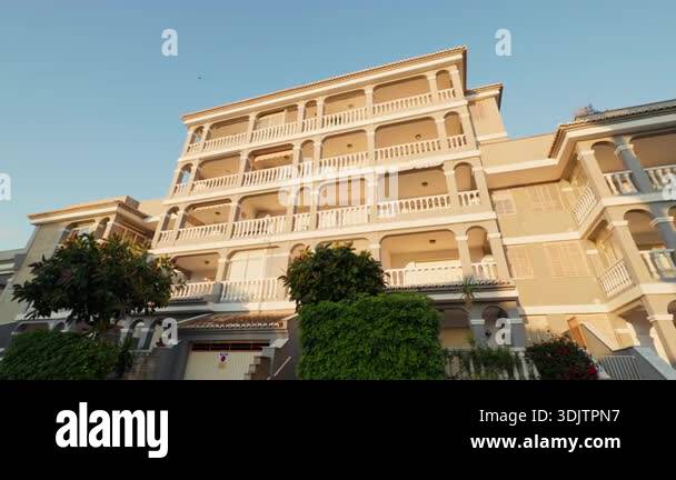Vintage hotel with columned terraces under clear sky in downtown low ...