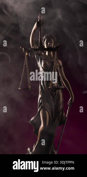 Mysterious smoke swirling around a bronze Lady Justice statue holding a ...