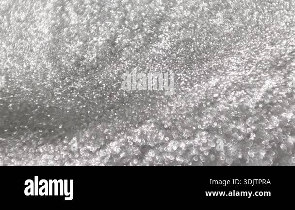 Close-up of sparkling silver glitter particles shimmering intensely and ...