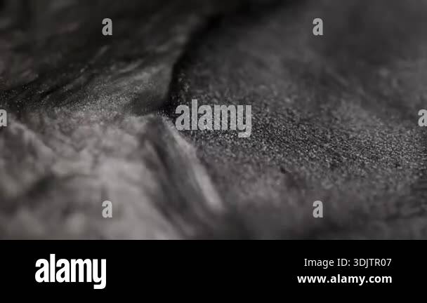 Silky liquid platinum paint flowing slowly to create deep folds and ...