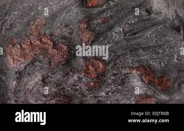 Macro shot of dark titanium and bronze paint slowly flowing and merging ...