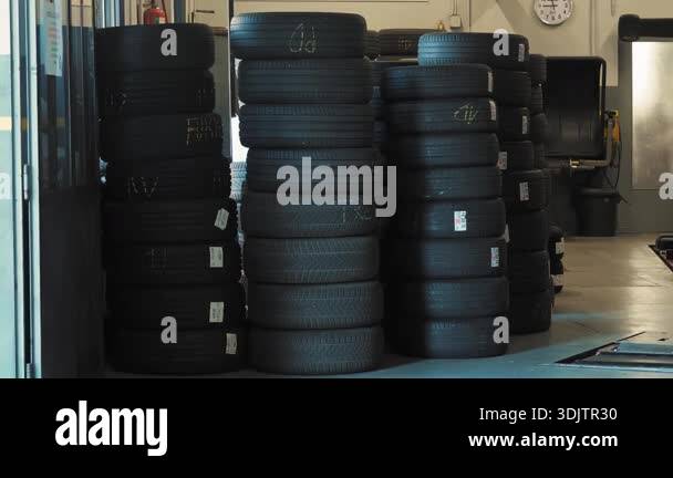 Black rubber tires stacked on top of each other in parts store or ...