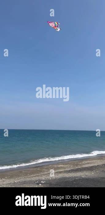 Single kite flying over calm sea horizon under clear blue sky. Minimal ...