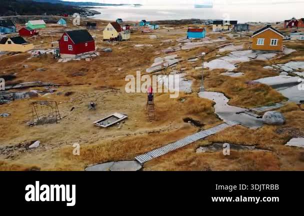 Person walking in Arctic village with colorful houses, wooden paths and ...