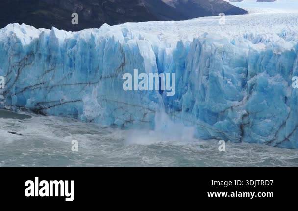 Arctic glacier front with blue ice wall and cold seawater in Greenland ...