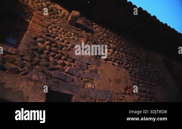 Fragment of stone tower of ancient Italian fortress illuminated by ...