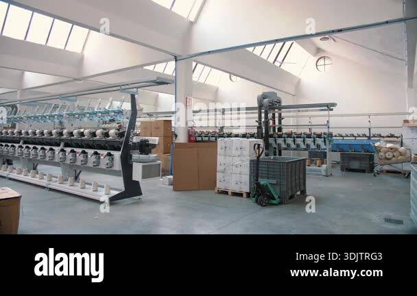 Automated textile machinery rewinding yarn bobbins in industrial ...