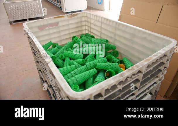 Perforated plastic coloring tubes or cones for yarn dyeing collected in ...