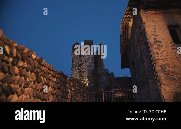 Medieval tower and stone walls of Italian castle illuminated by night ...